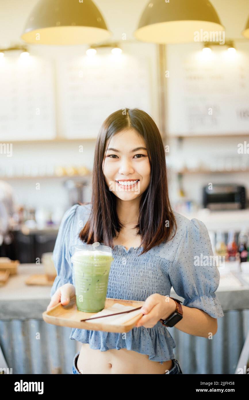 Happy smiling asian women drinking with ice matcha green tea indoor ...