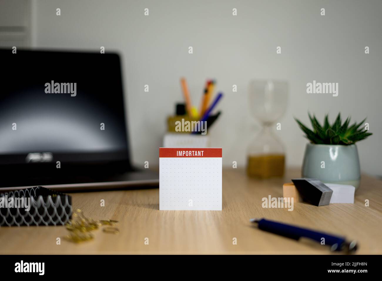 A notepad for important notes on a cluttered office desk with a laptop ...