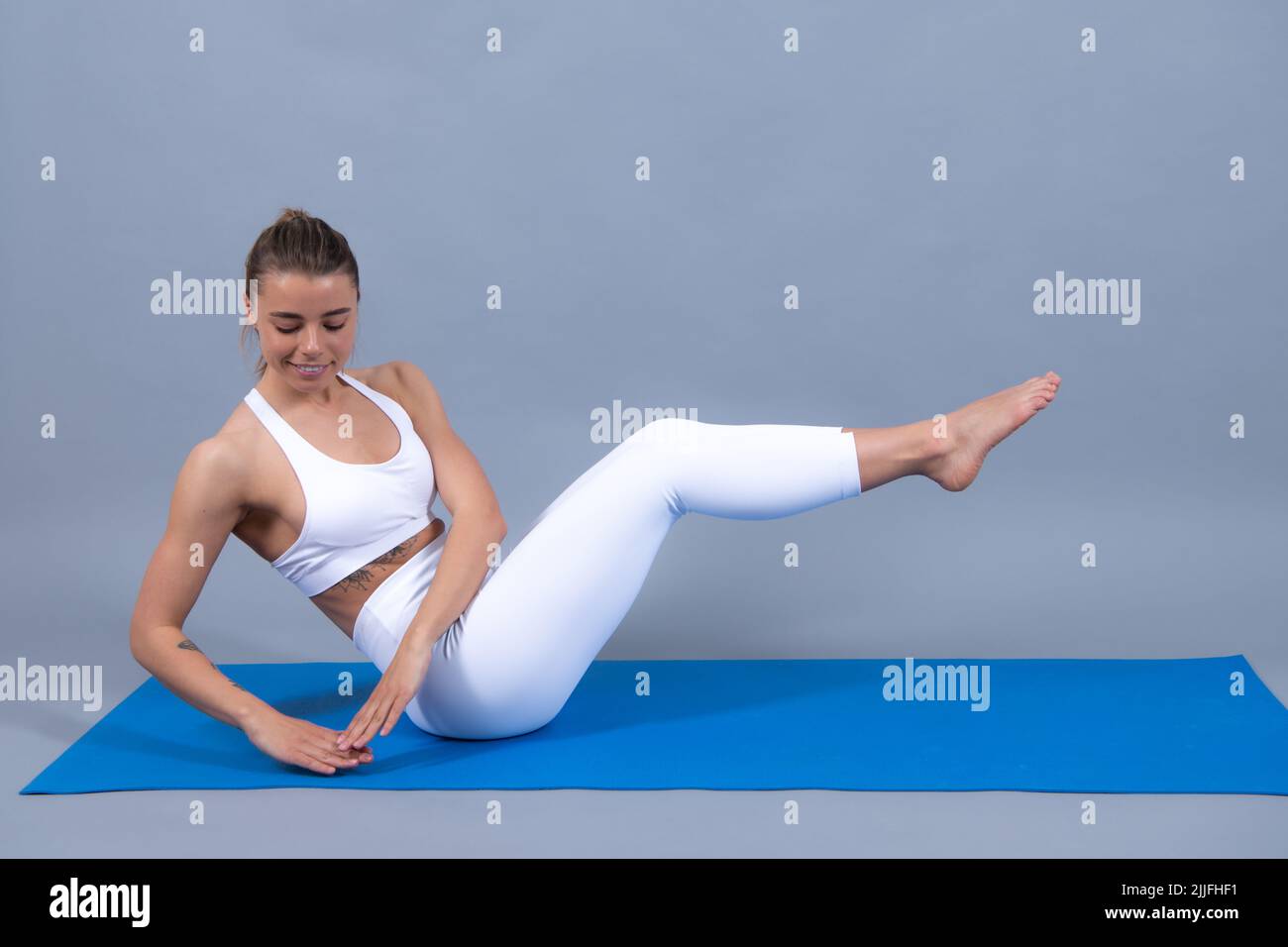Six pack abs training. Young woman practicing yoga extended asana in ...