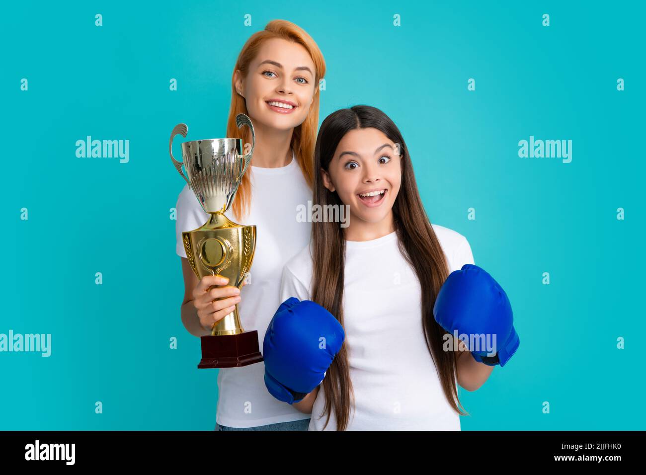Mommy and teen daughter in boxing gloves holding winning prize, showing ...