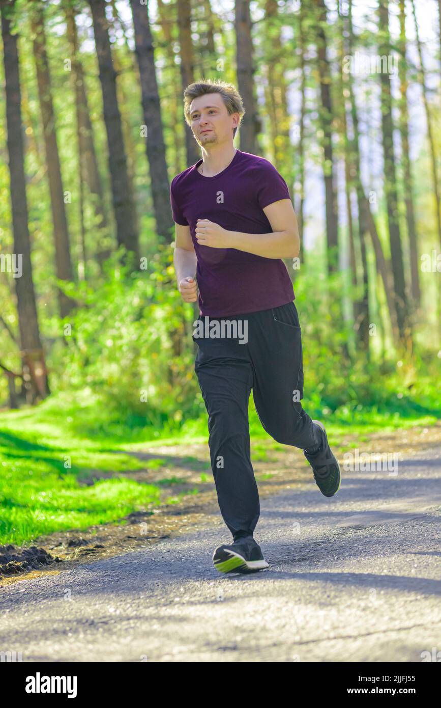 Running man jogging in city park at beautiful summer day. Sport fitness ...
