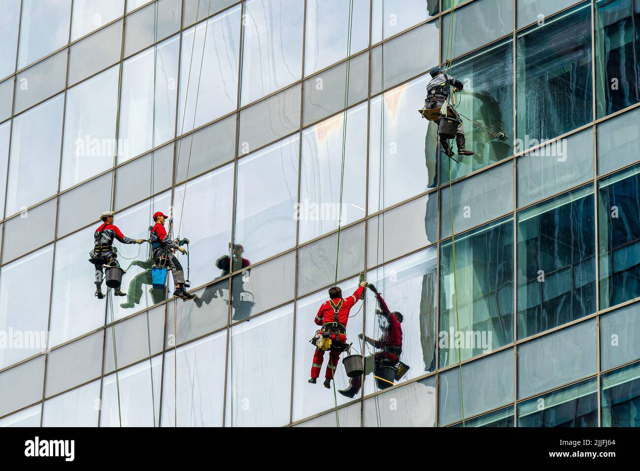 Group of industrial climbers cleaning windows on the facade of an ...
