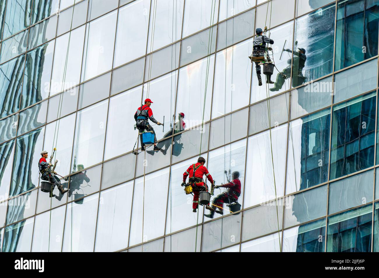 Group of industrial climbers cleaning windows on the facade of an ...