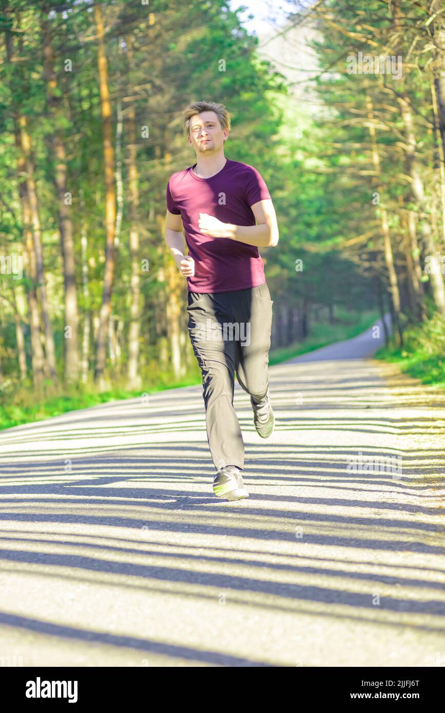 Running man jogging in city park at beautiful summer day. Sport fitness ...