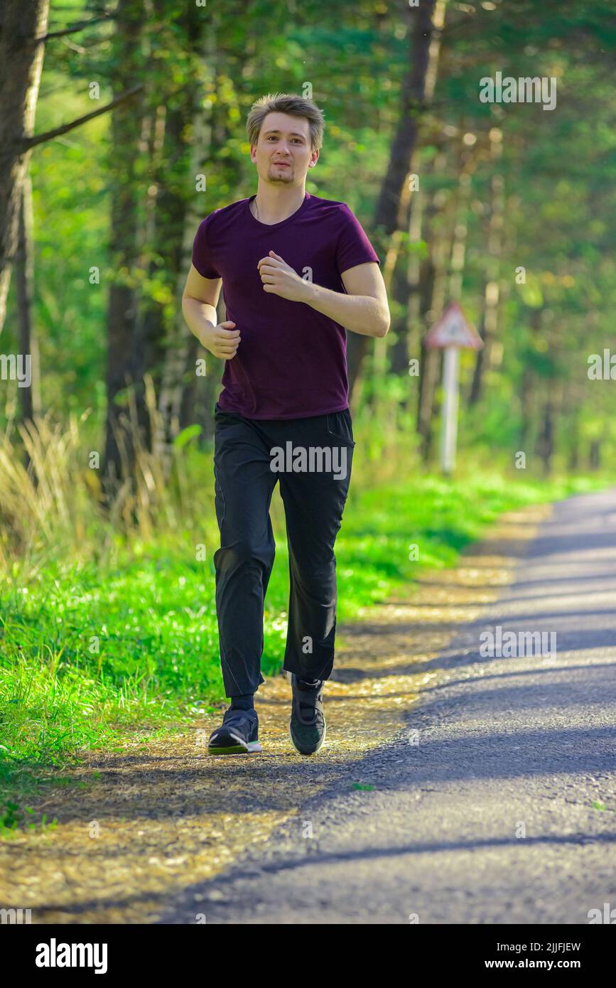 Running man jogging in city park at beautiful summer day. Sport fitness ...