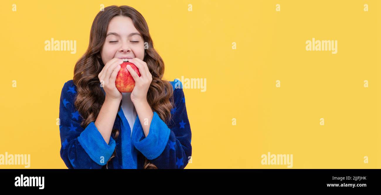 so tasty and juicy. excited child in pajama eating apple. morning ...