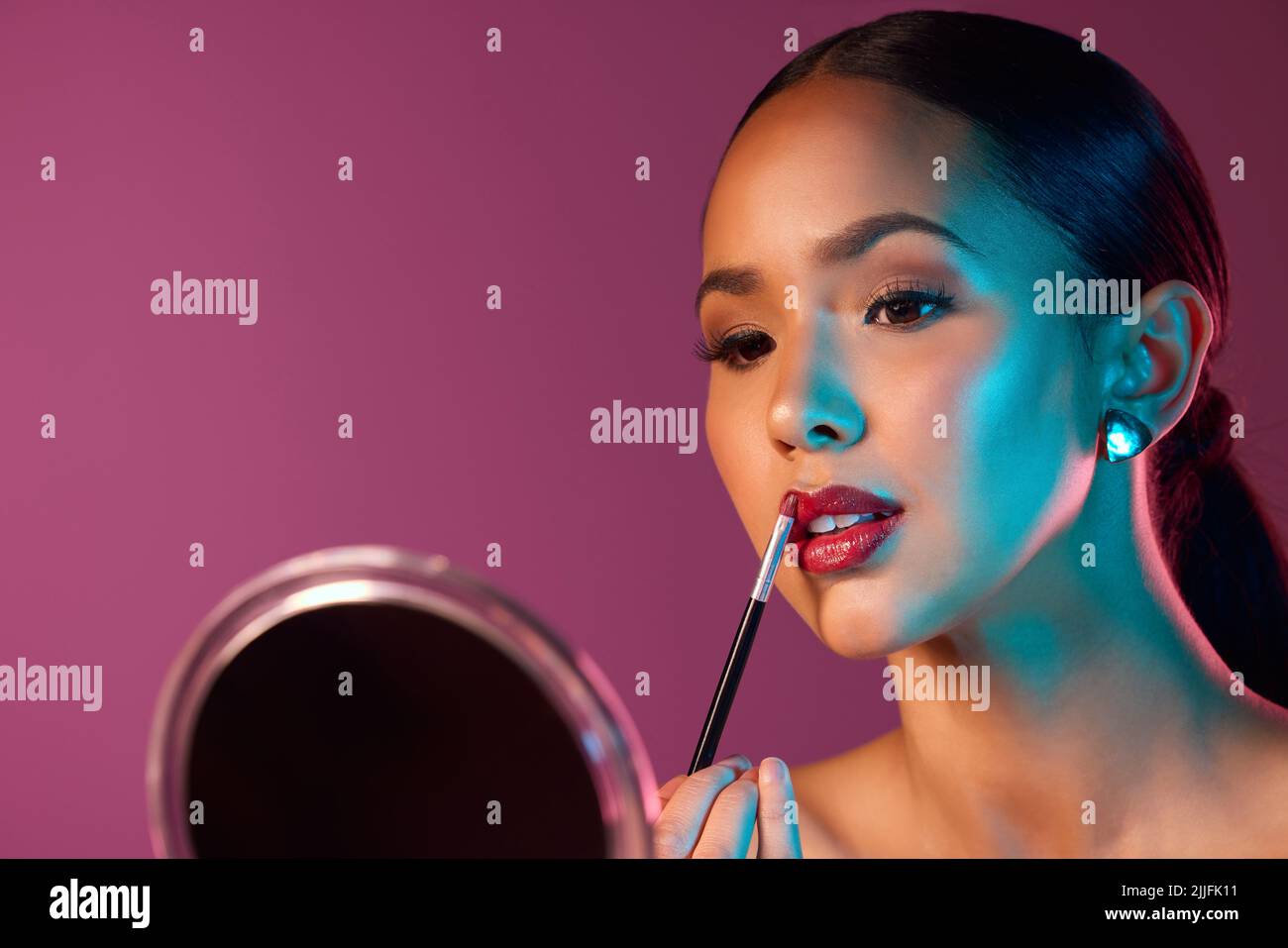 Reflecting on beauty. an attractive young woman posing in studio ...