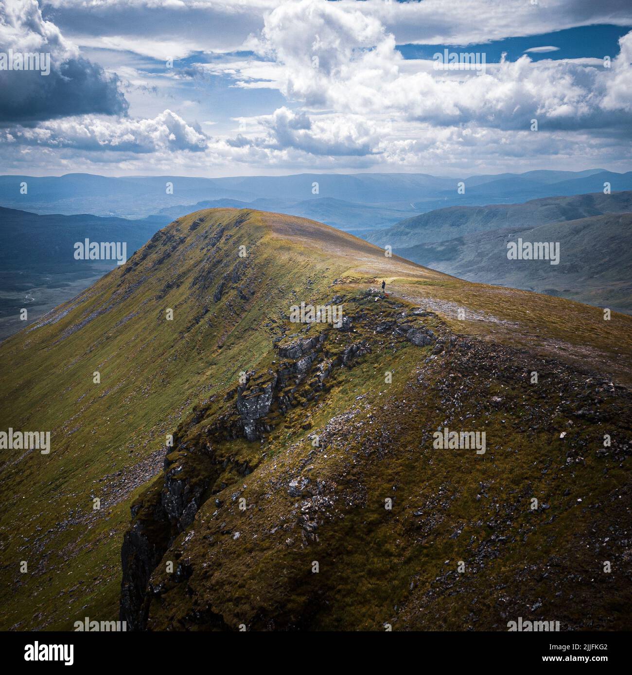 An aerial view of a person standing on the peak of the mountain Stock ...