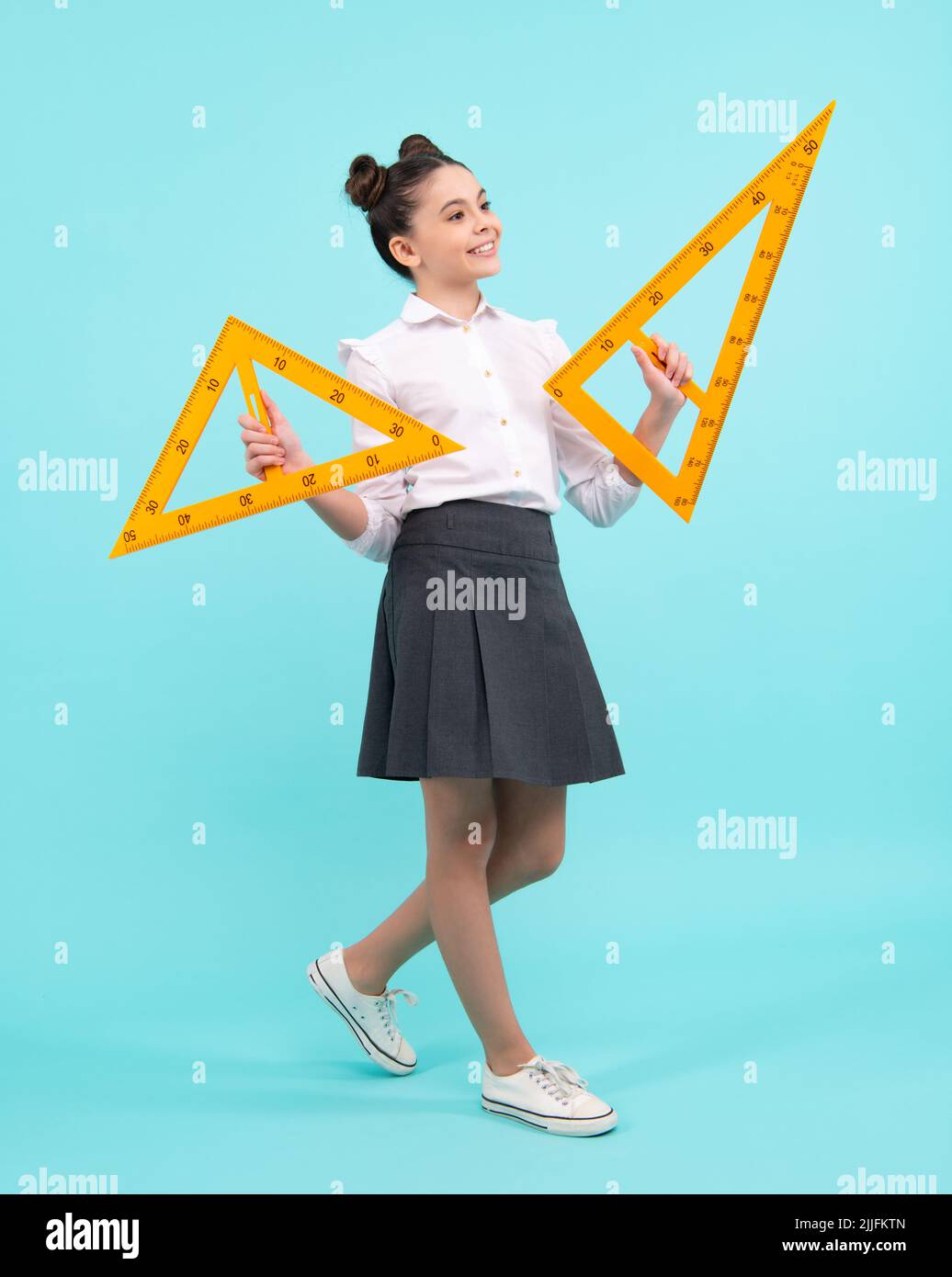 Back to school. School girl hold ruler measuring isolated on blue ...
