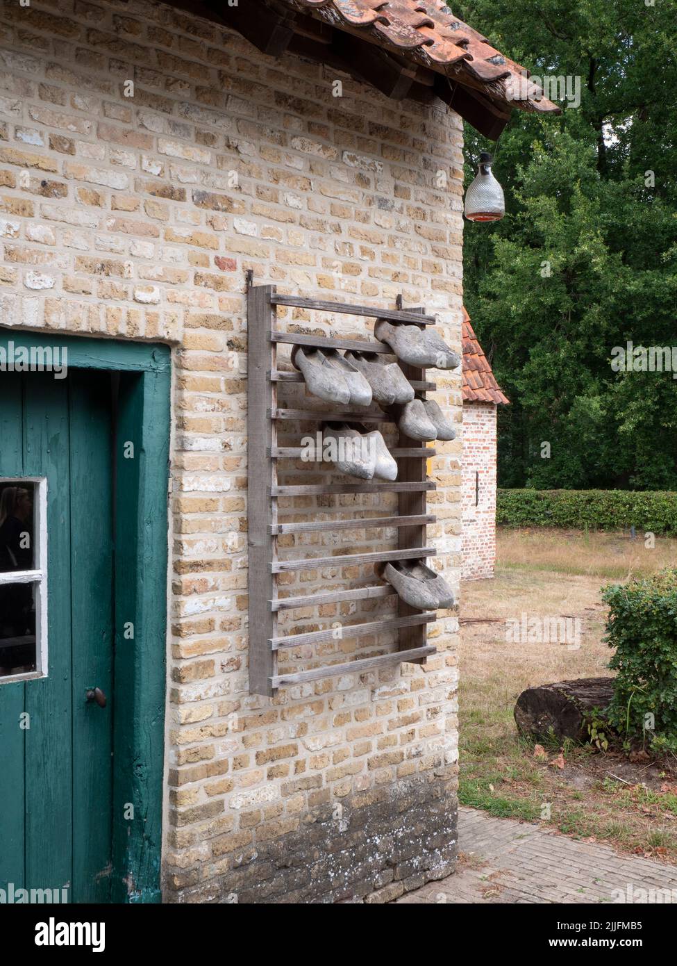 Facade of an old house with a wooden rack and wooden weathered clogs ...