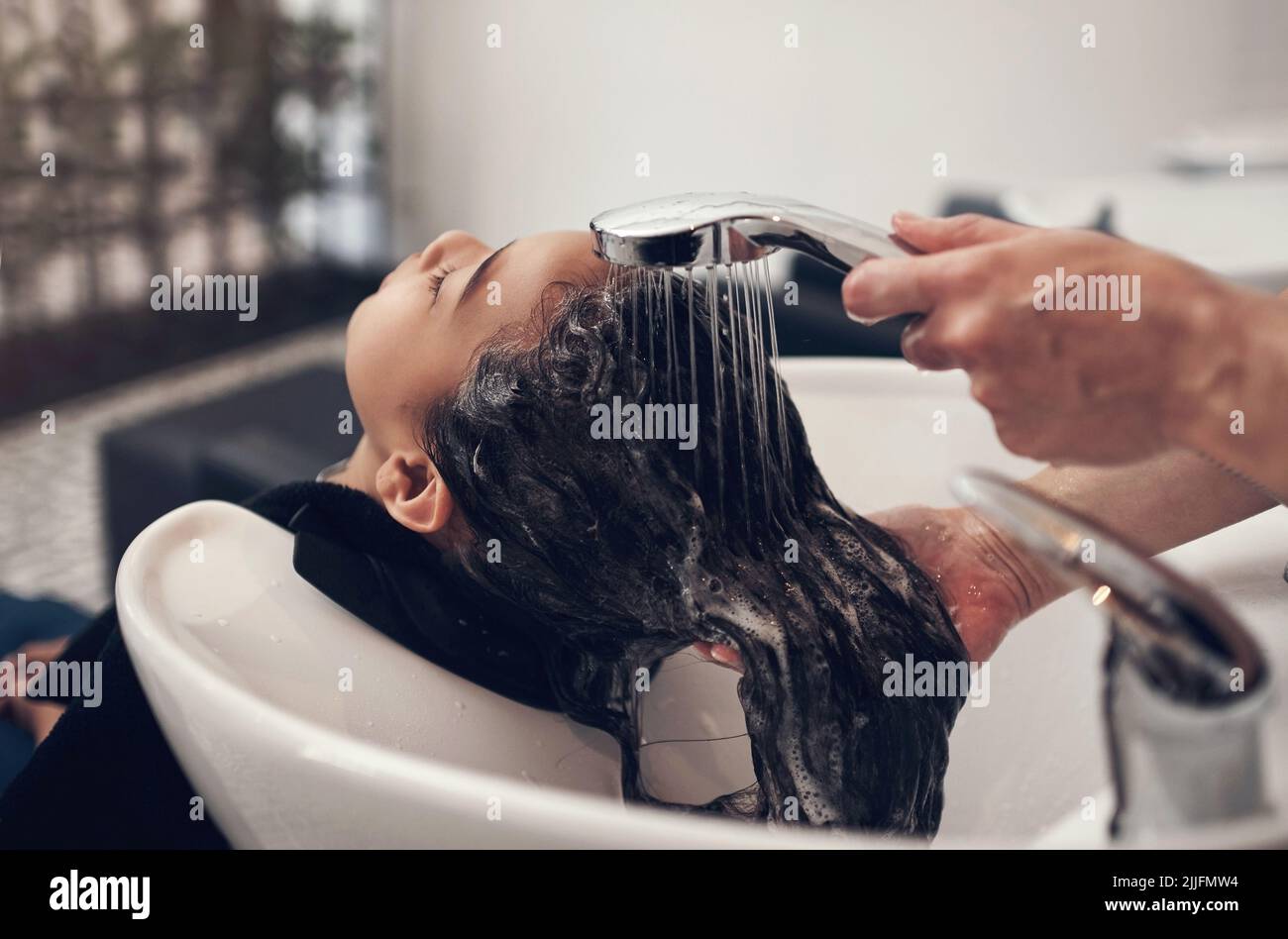 Rinsing makes all the difference. a young girl getting her hair washed ...