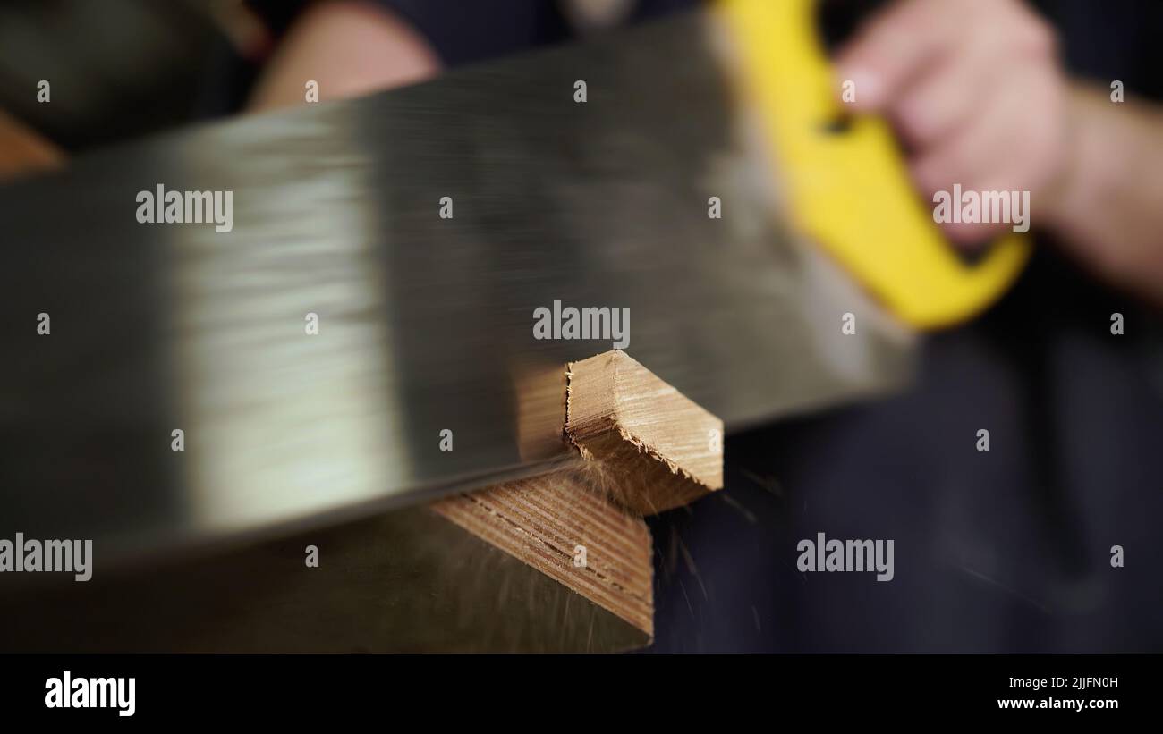 Handwork concept, woodworking workshop. Carpenter saws wooden board ...