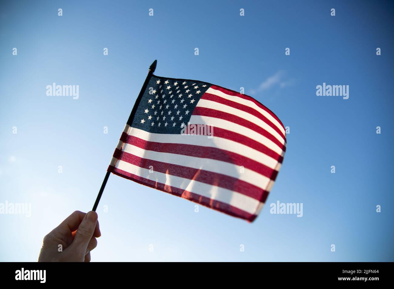 Hand holding American flag. National symbol of the United States of ...