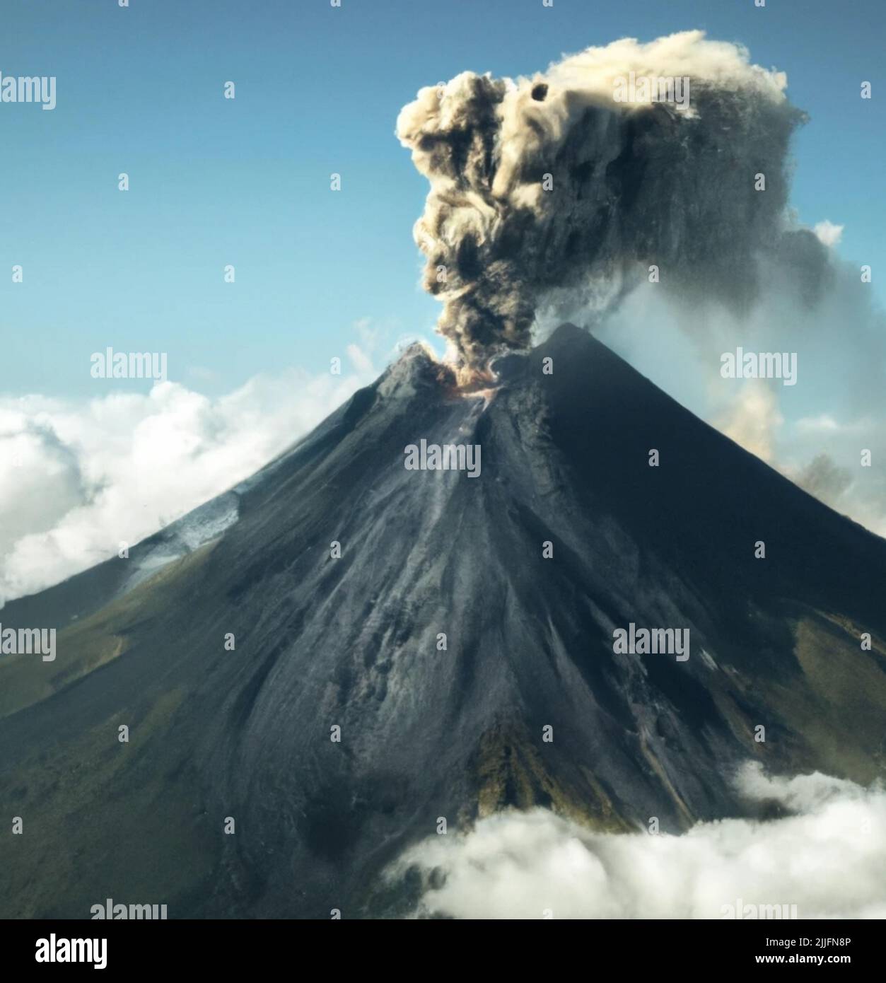 A breathtaking view of a volcano erupting against a blue sky Stock ...