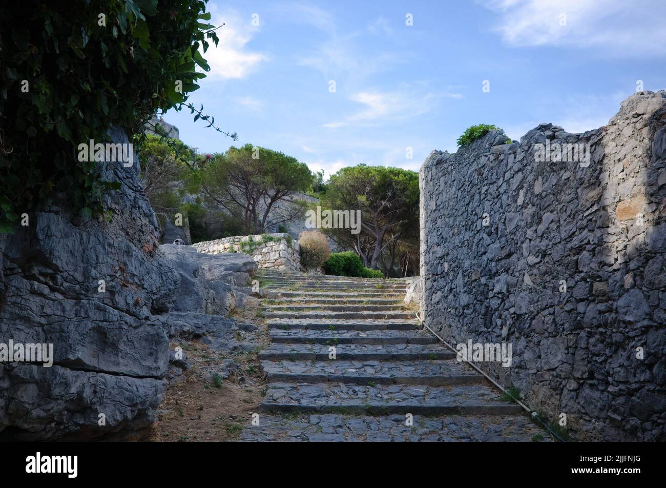 Ancient stone stair leading up between rocks and remains of medieval ...