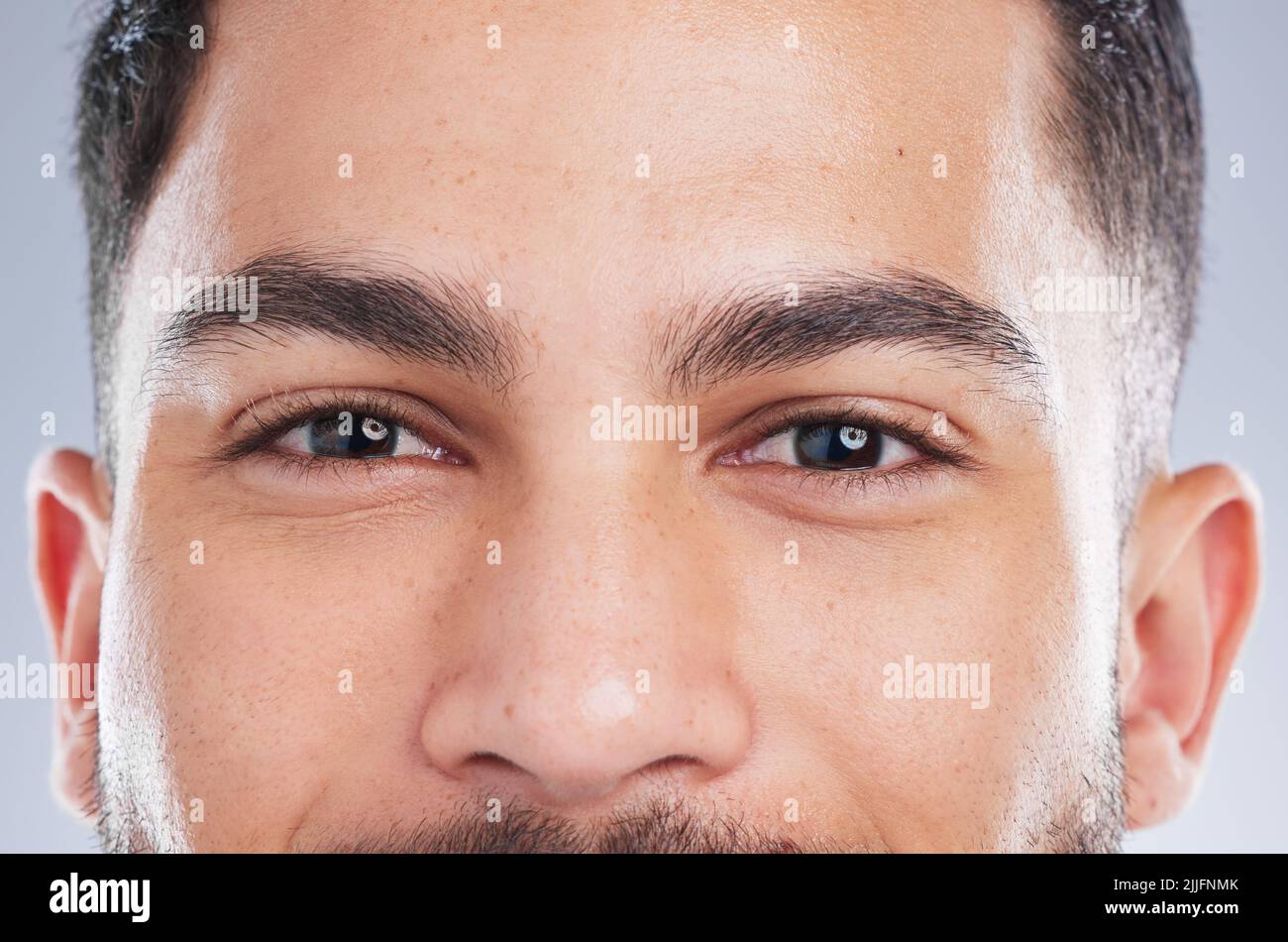 Its the eyes that smile first. an handsome young mans eyes against a ...