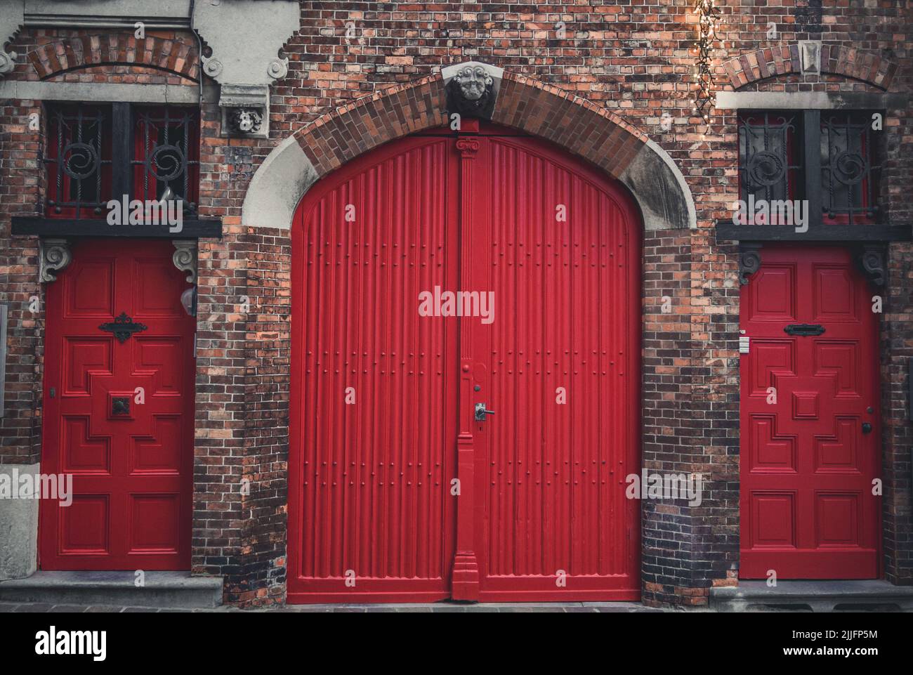 Traditional shiny wooden red entrance doors of a building in Bruges ...