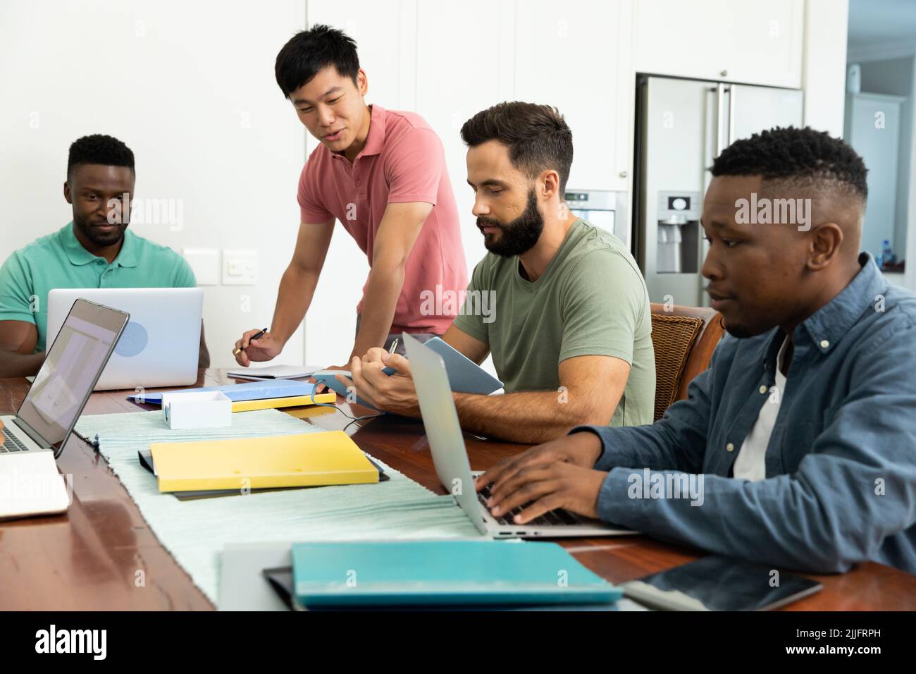 Multiracial businessman describing project to colleagues working over ...
