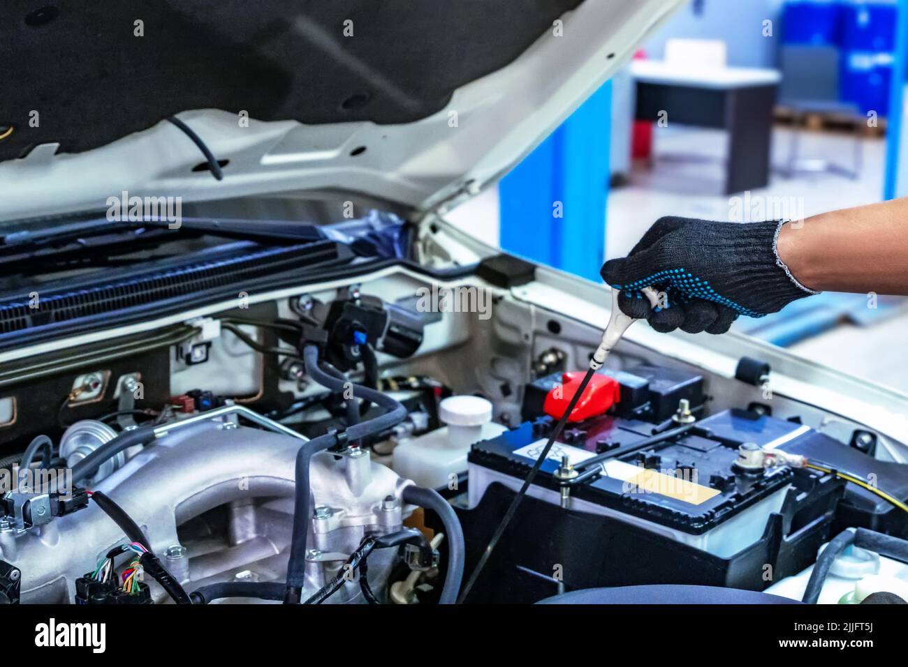 Auto mechanic works with car hood open in car repair shop. Official car ...
