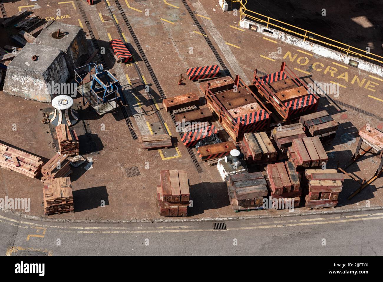 heavy weights and wood and crane stuff on the ground at a harbor dry ...