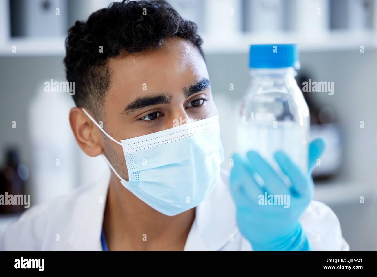 Working towards a new discovery. a young man analysing a sample in a ...