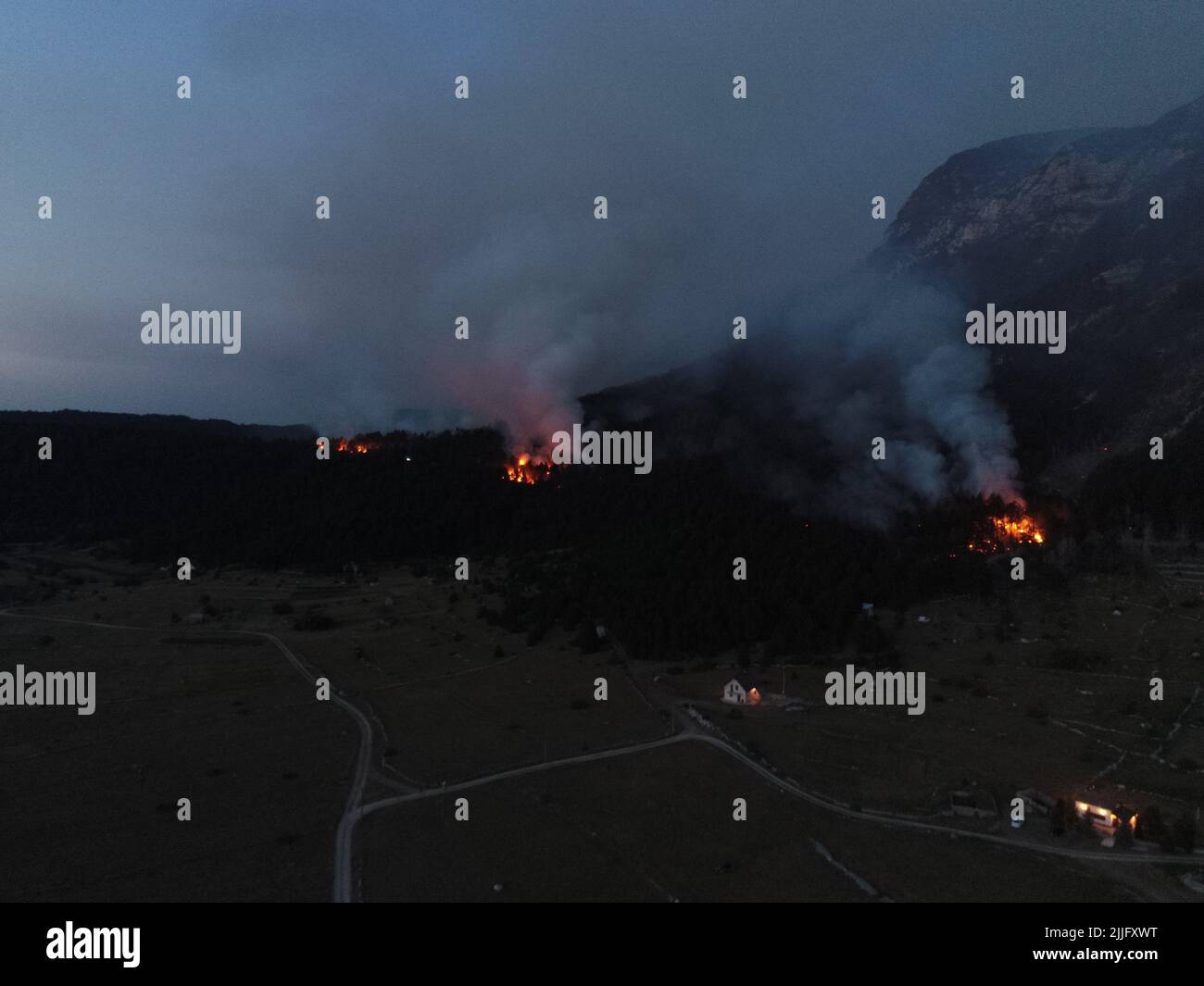 Aerial panoramic view of a forest fire at night, heavy smoke causes air ...