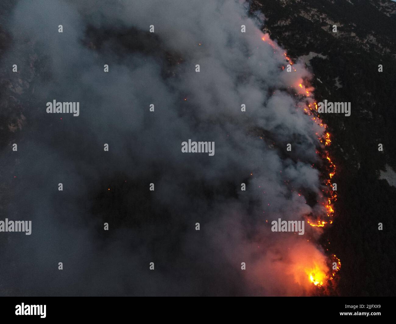 Aerial panoramic view of a forest fire at night, heavy smoke causes air ...
