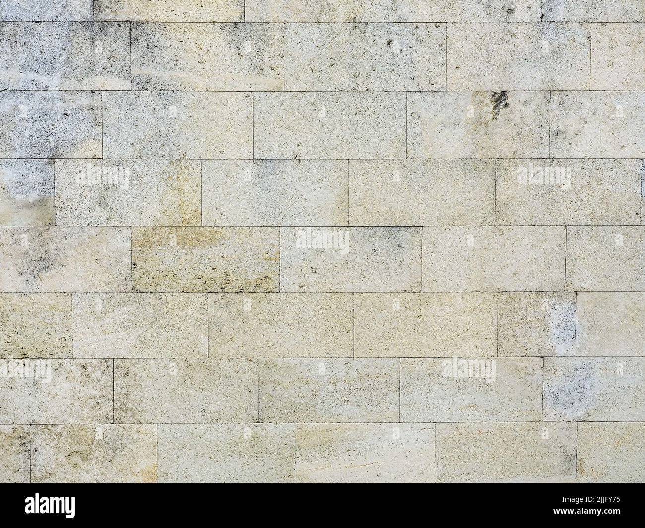 Wall made of white decorative stone. Granite tiles for cladding ...