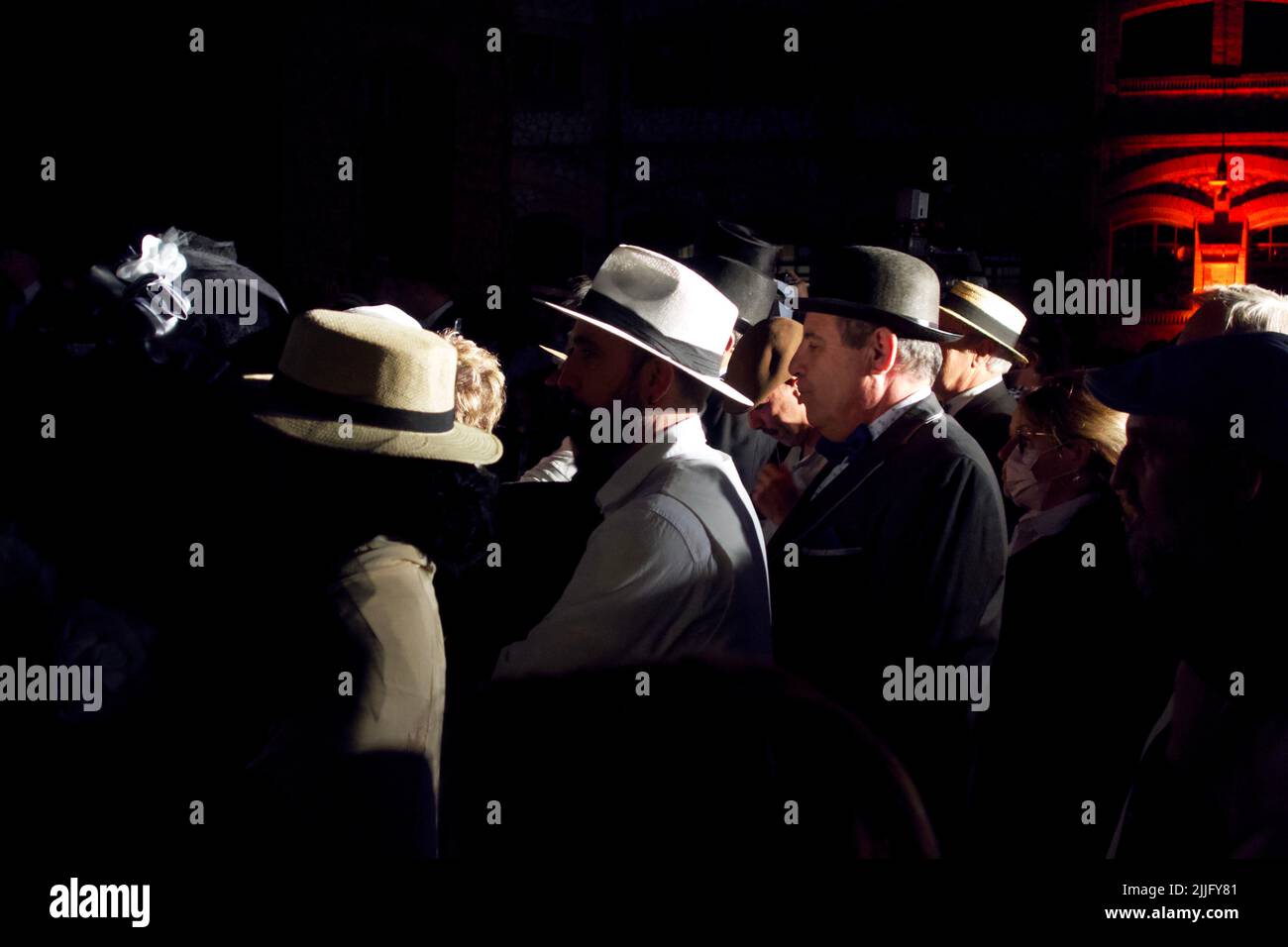 A group of people in hats standing in a row by contrast lighting Stock ...
