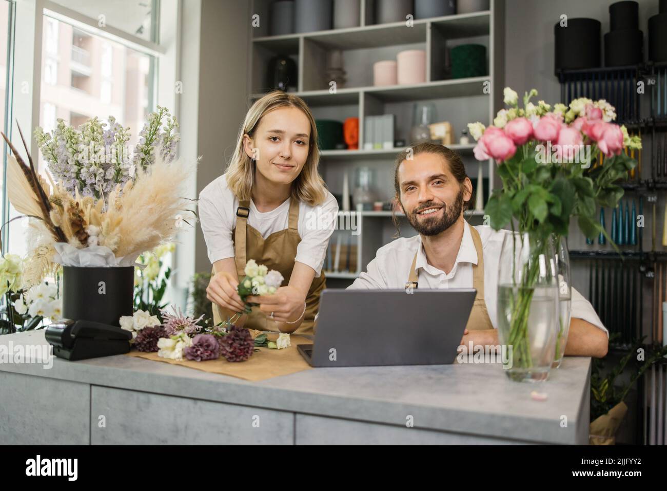 Two workers, man florist working on computer at workplace and woman ...