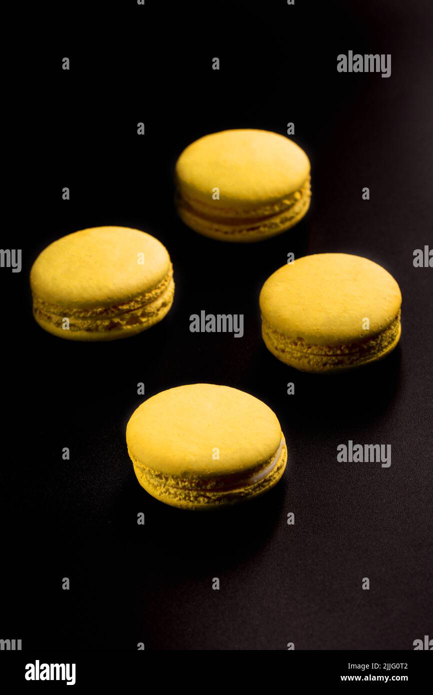 Yellow Macarons on a black background French pasta. Stack of yellow ...
