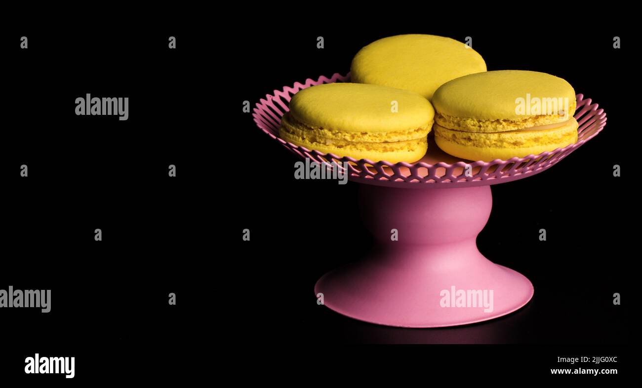 Yellow Macarons on a black background French pasta. Stack of yellow ...