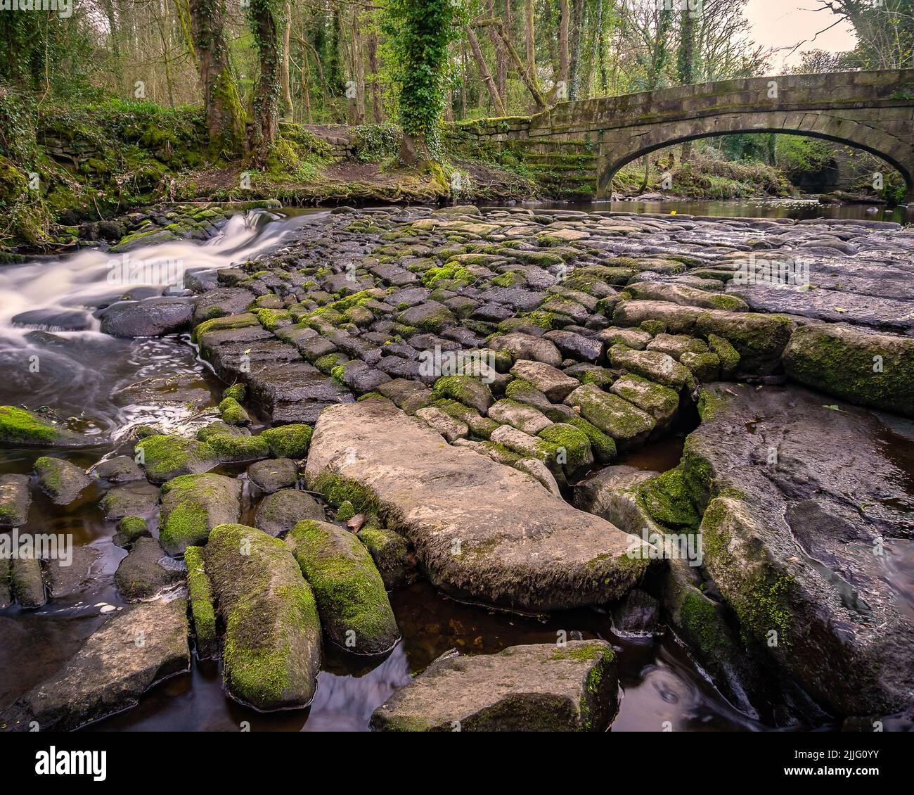 A long exposure river flowing over a rocky surface in Rivelin Valley ...