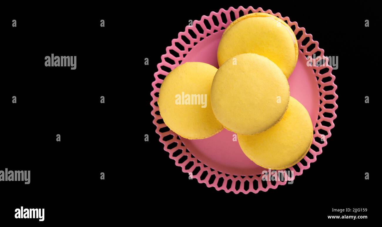 Yellow Macarons on a black background French pasta. Stack of yellow ...