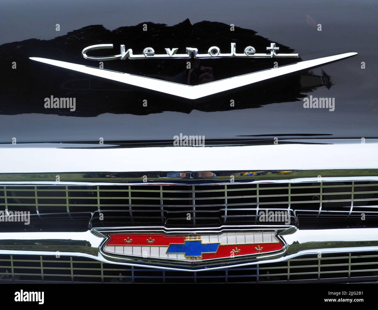 A closeup of a black classic vintage Chevrolet car hood bonnet detail ...
