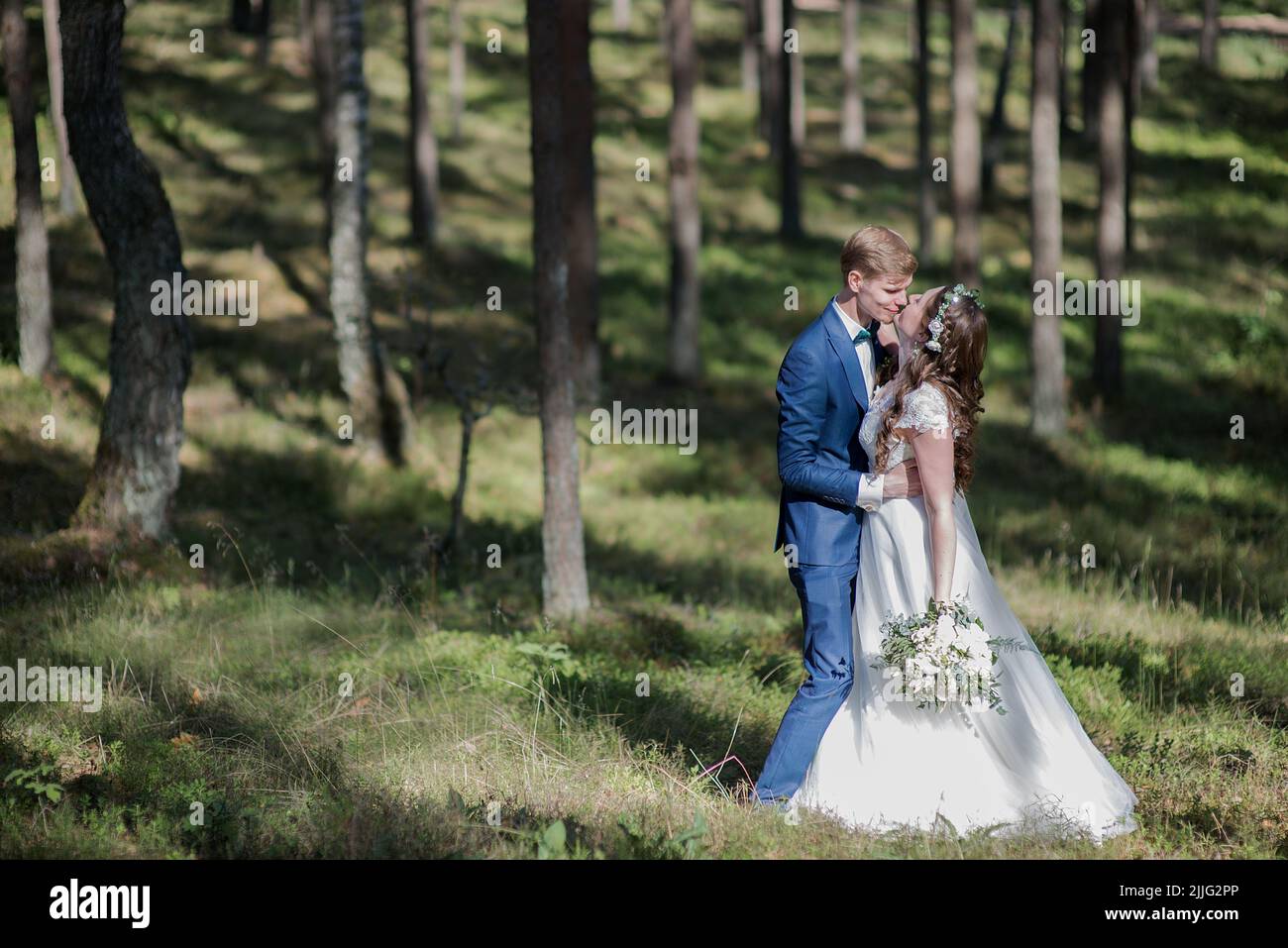 A happy caucasian couple kissing while taking a wedding photoshoot in a ...