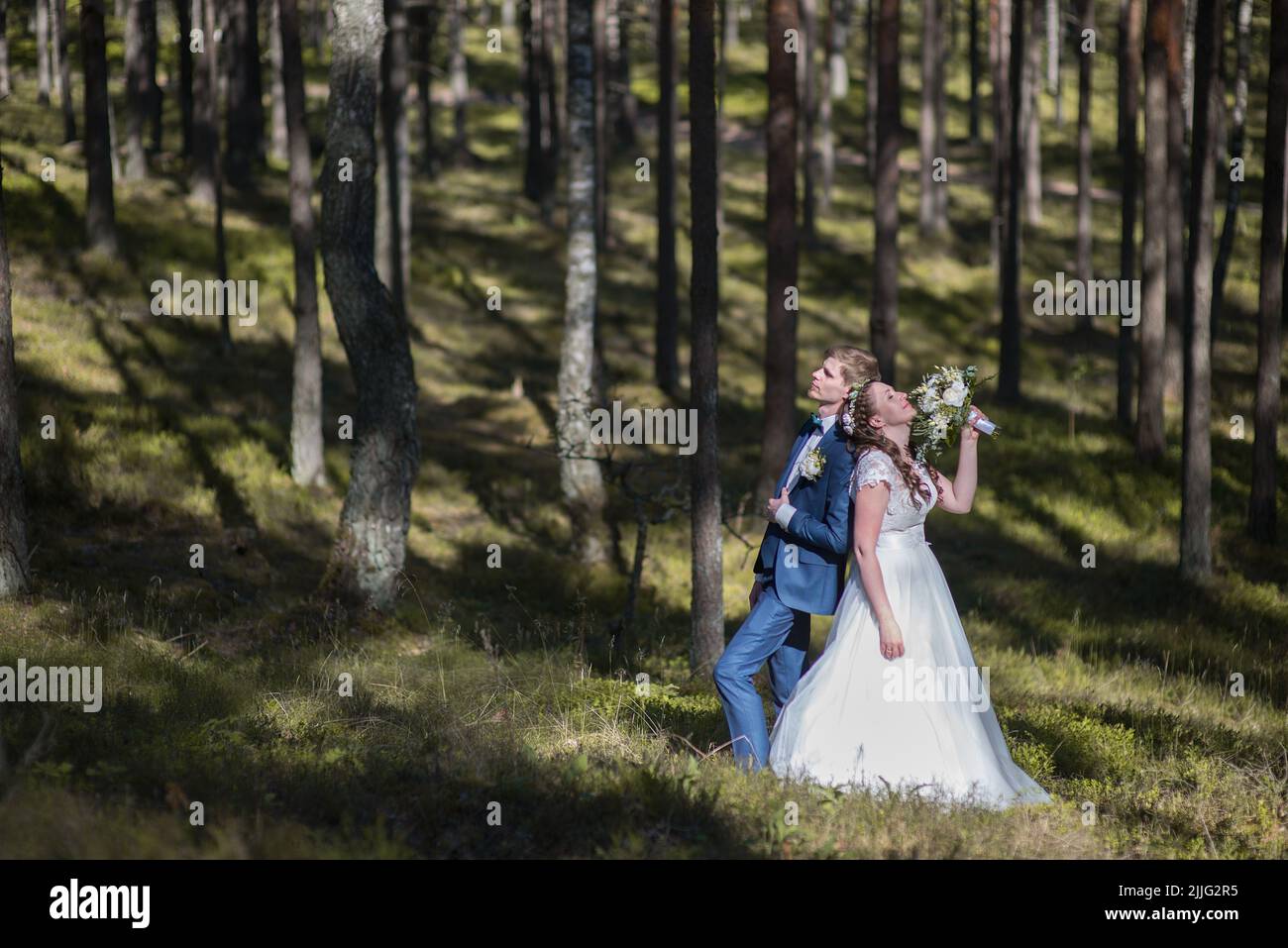 A happy caucasian couple taking a wedding photoshoot in a forest Stock ...