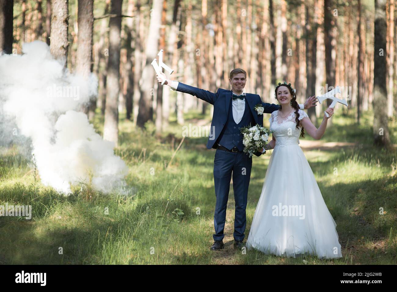 A happy caucasian couple taking a wedding photoshoot in a forest Stock ...