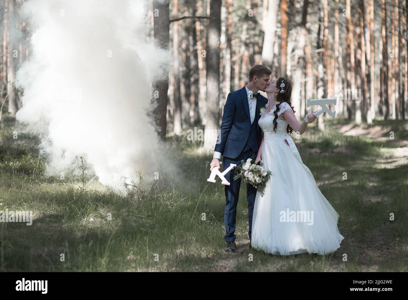 A happy caucasian couple kissing while taking a wedding photoshoot in a ...