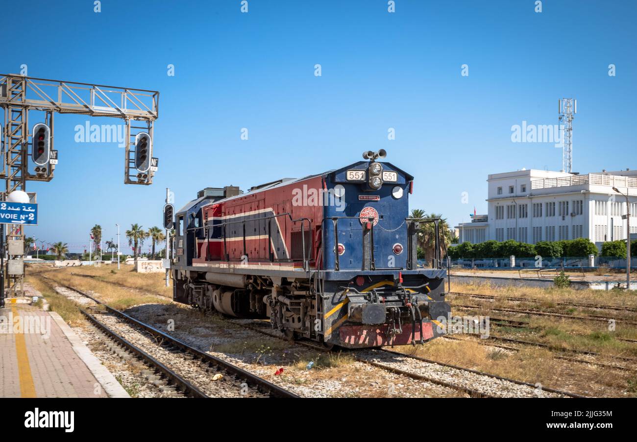 A Tunisian National Railways diesel locomotive passes train signals at ...