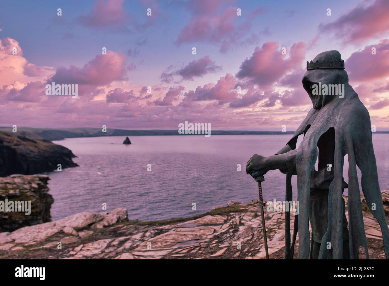 The statue at Tintagel Castle against a purple cloudy sky Stock Photo ...