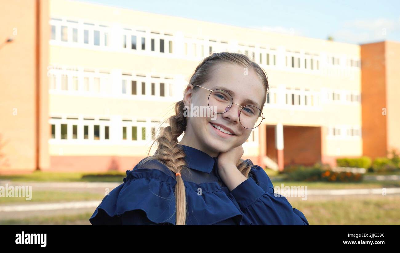 A teenage girl wearing glasses in front of a school Stock Photo - Alamy