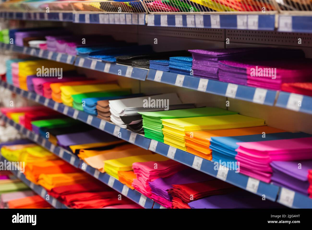 rack with multicolored plastic files and folders in stationery store ...