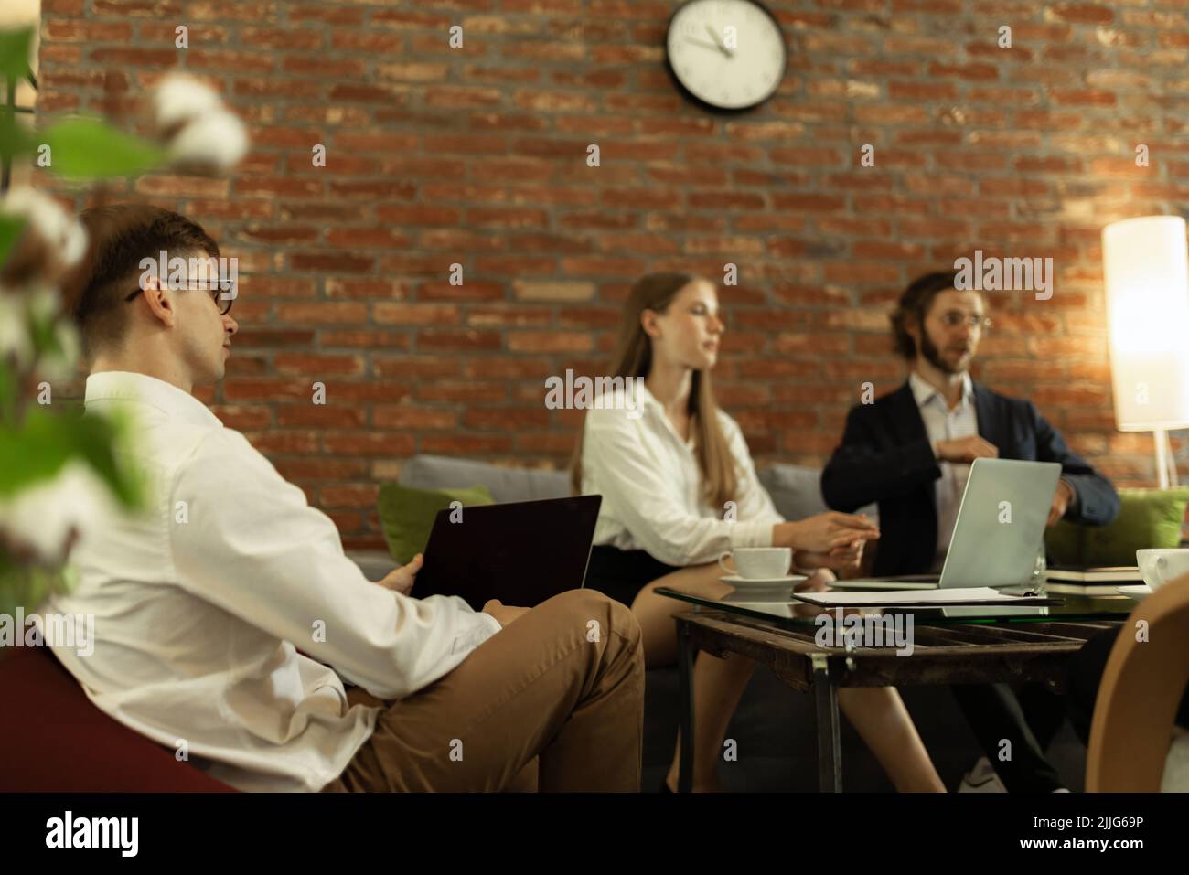 Group of young people having english lesson with tutor at modern office ...