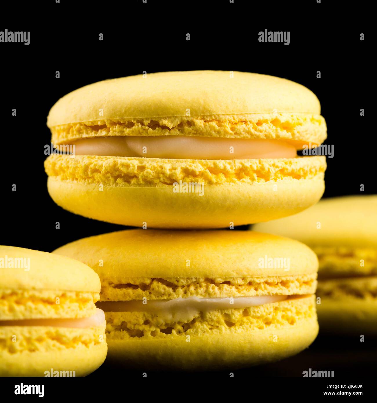 Yellow Macarons on a black background French pasta. Stack of yellow ...