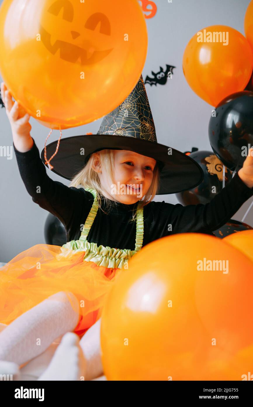 Children's Halloween - a girl in a witch hat and a carnival costume ...