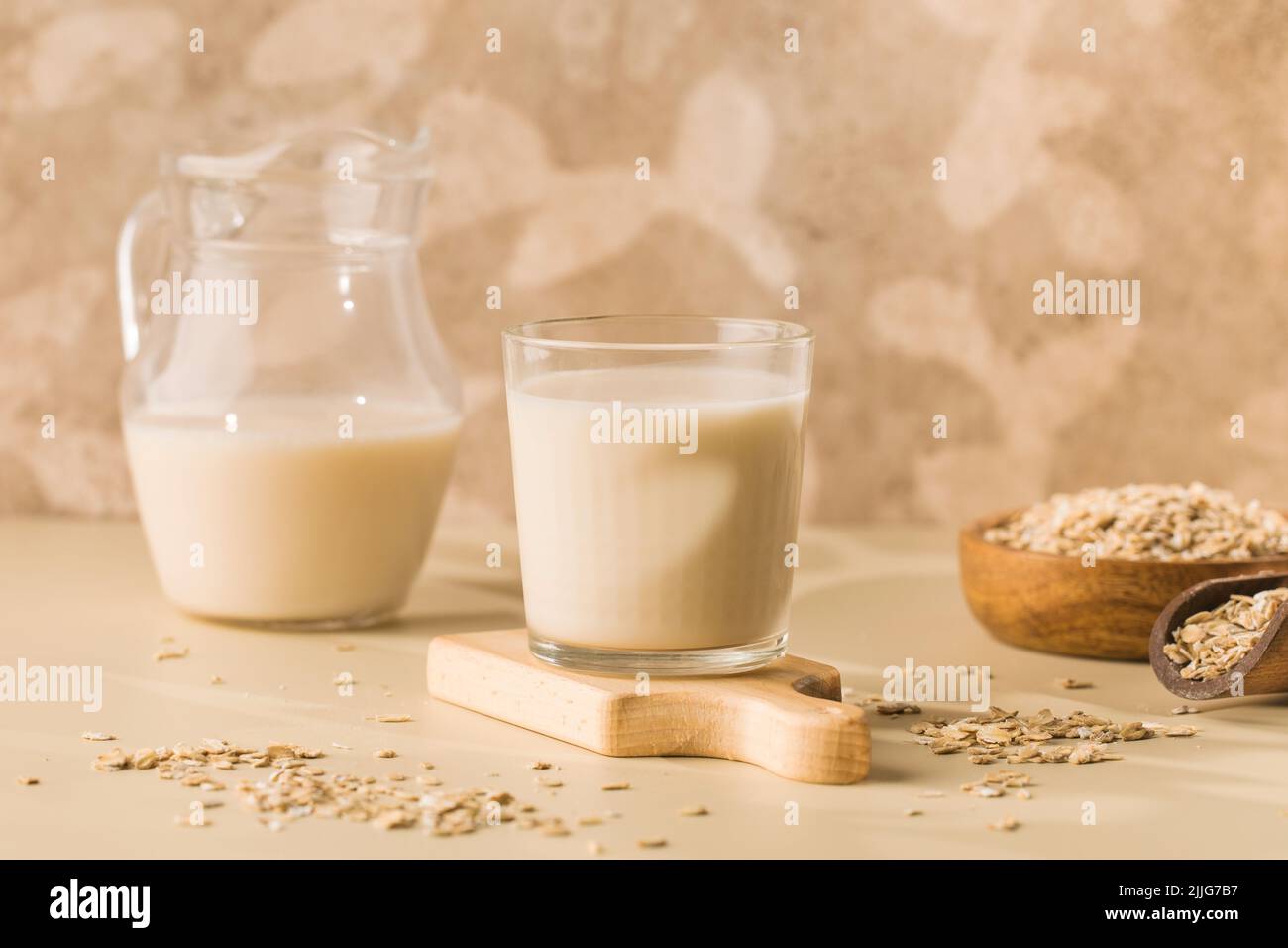 A glass of oat milk, a jug and oat flakes. The concept of alternative ...