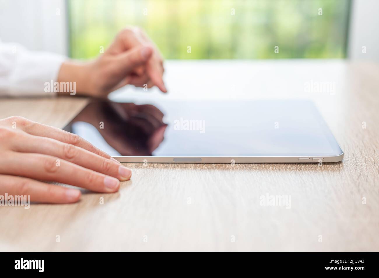 Tablet with a blank screen in the hands on wooden table Stock Photo - Alamy