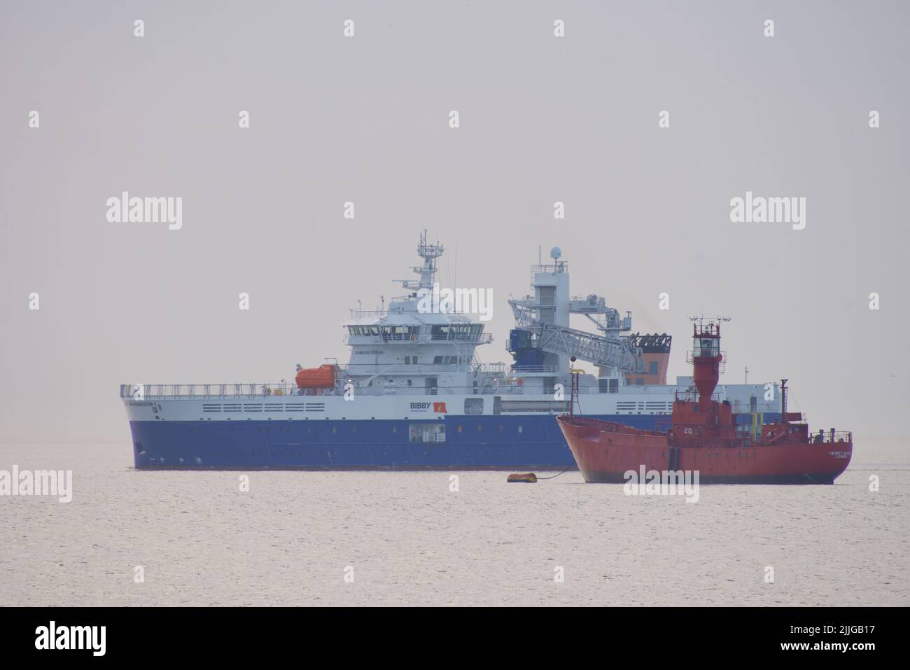 Two cargo ships navigating in the peaceful sea near Felixstowe, Suffolk ...
