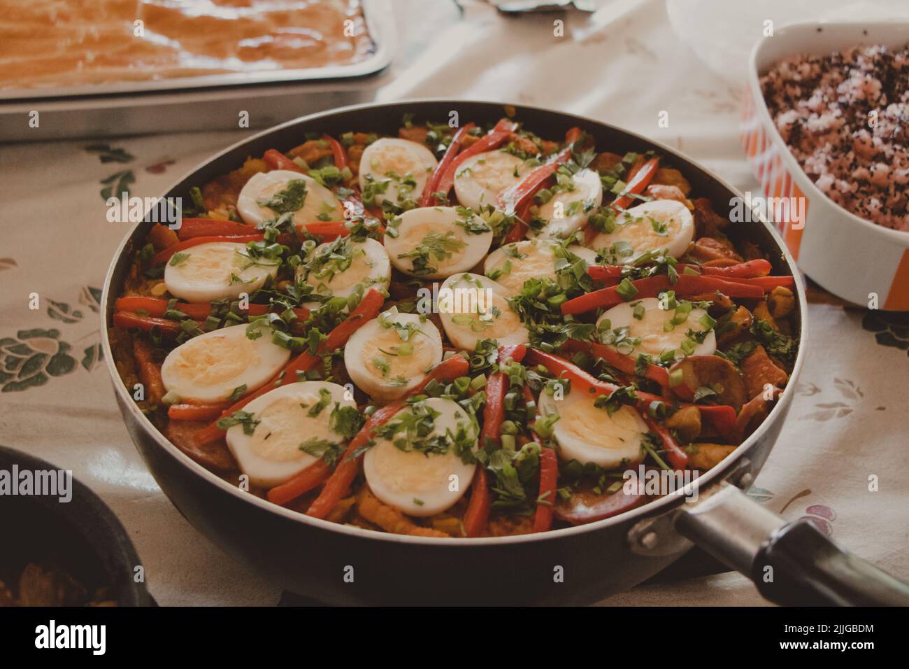 big pan with pork paella and eggs on the top Stock Photo - Alamy